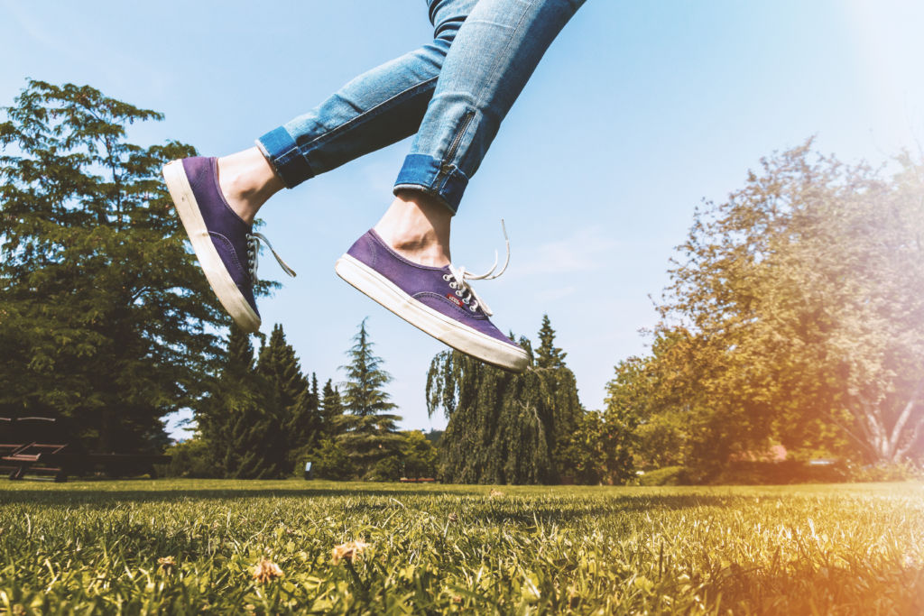 Female legs jumping on the grass outdoors in the park · Free Stock Photos